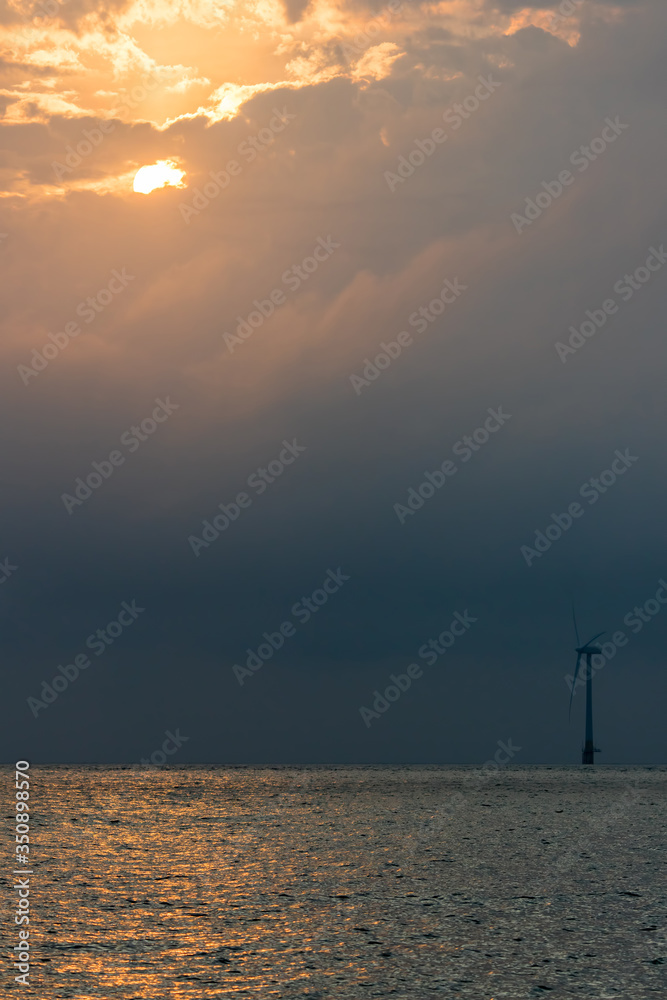 Standing against climate change. Solitary offshore wind turbine. Global ...