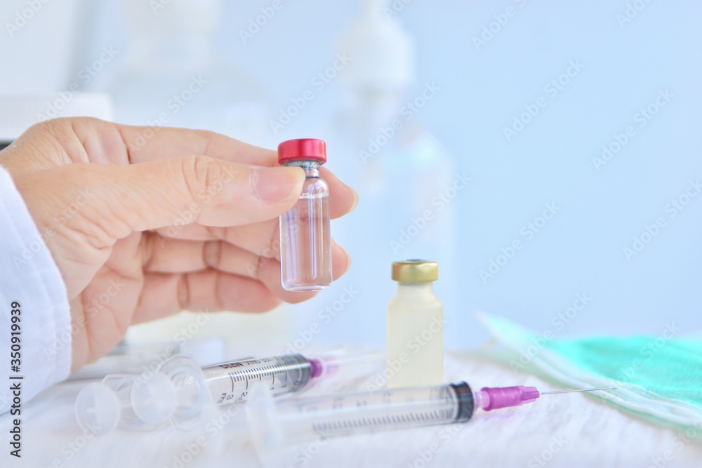Vaccine bottle in the hands of the doctor / experimenter who is ...