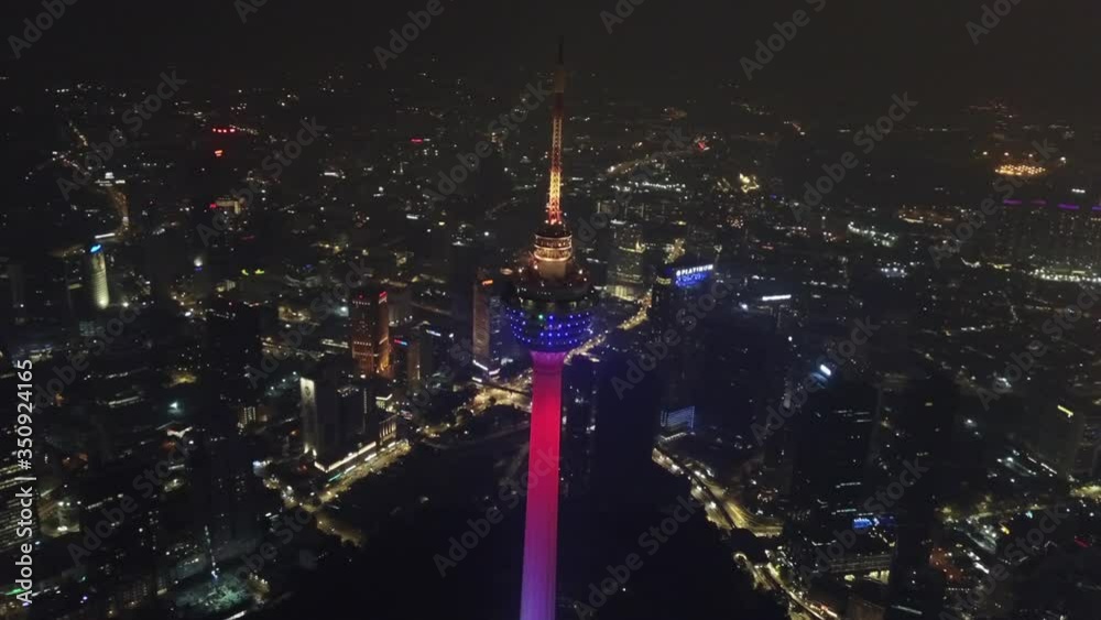 Rotating view of Menara Kuala Lumpur Tower at night. Aerial view of ...