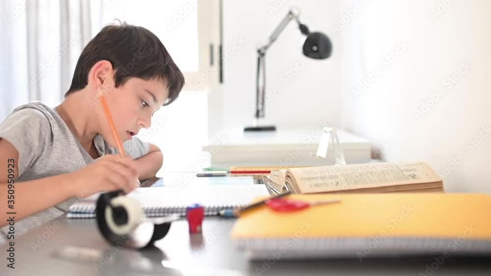 Stress kid doing homework.Boy at study table doing homework with stress ...