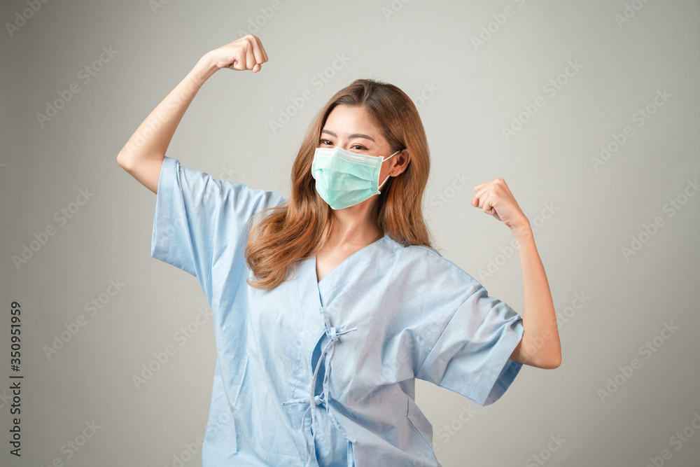 Portrait of a beautiful Asian woman in patient gown wearing surgical ...