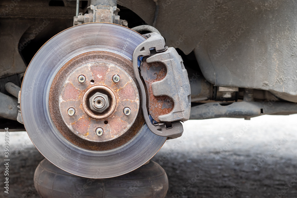 Rusty back car wheel hub with brake disc at tire shop. Car without a ...