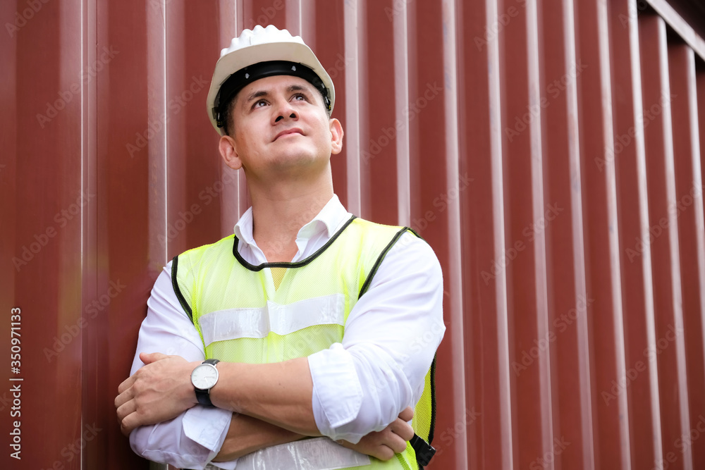 Engineer worker or technical standing in the container yard shipping ...