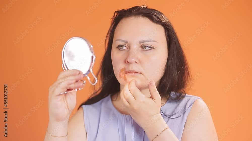 Sad young woman examines a real burn on the skin of her face in a ...