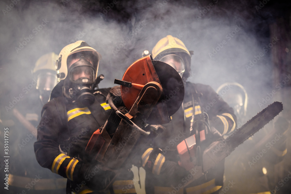 Group of professional firefighters wearing full equipment, oxygen masks ...
