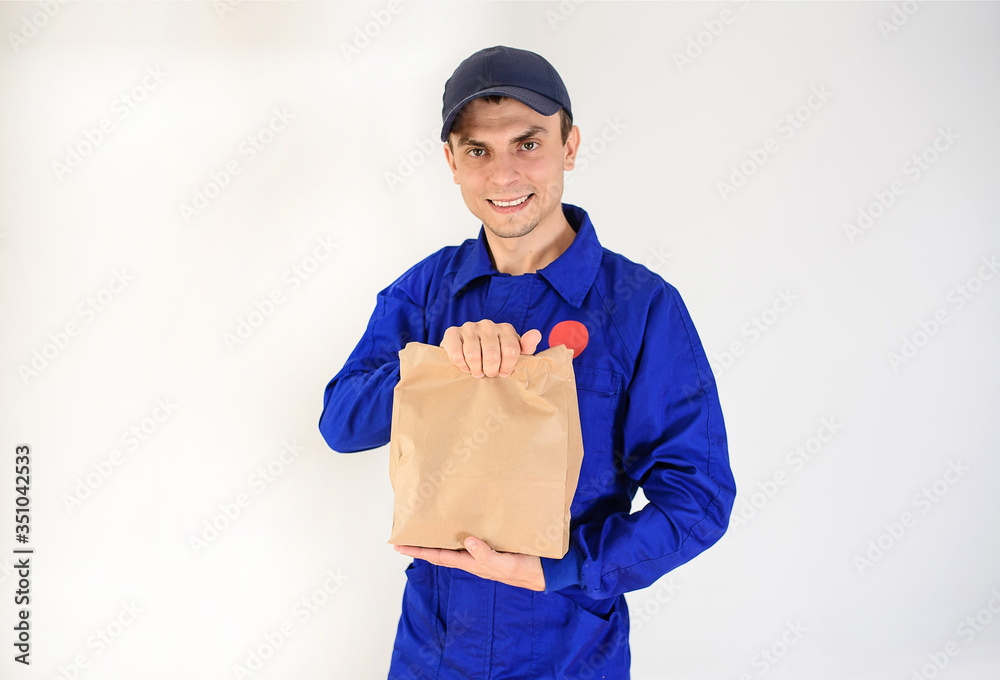 Young man courier is delivering a parcel in eco paper bag. Stock Photo ...
