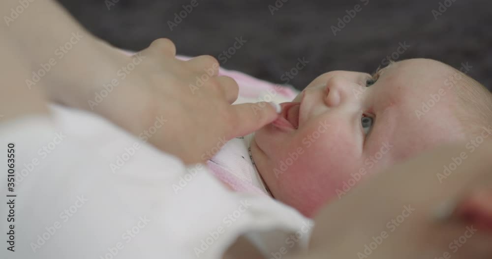 Close-up shooting. The mother is playing with the baby and tapping her ...