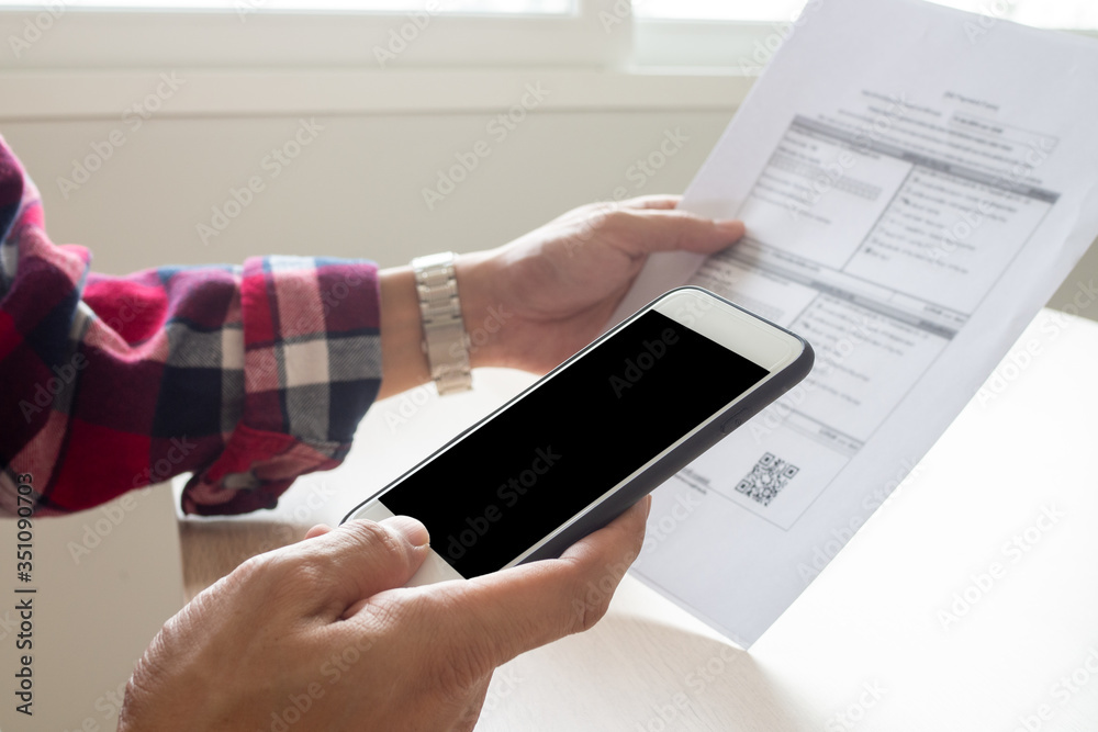 hand uses smartphone scan QR code or barcode to pay monthly phone bills ...
