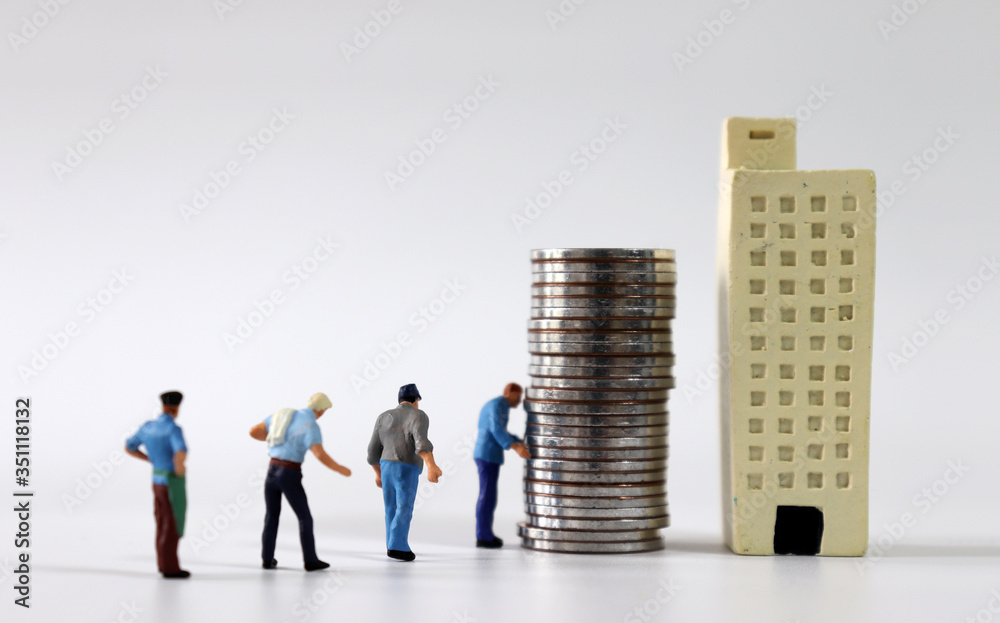Miniature people lining up in front of buildings and piles of coins ...