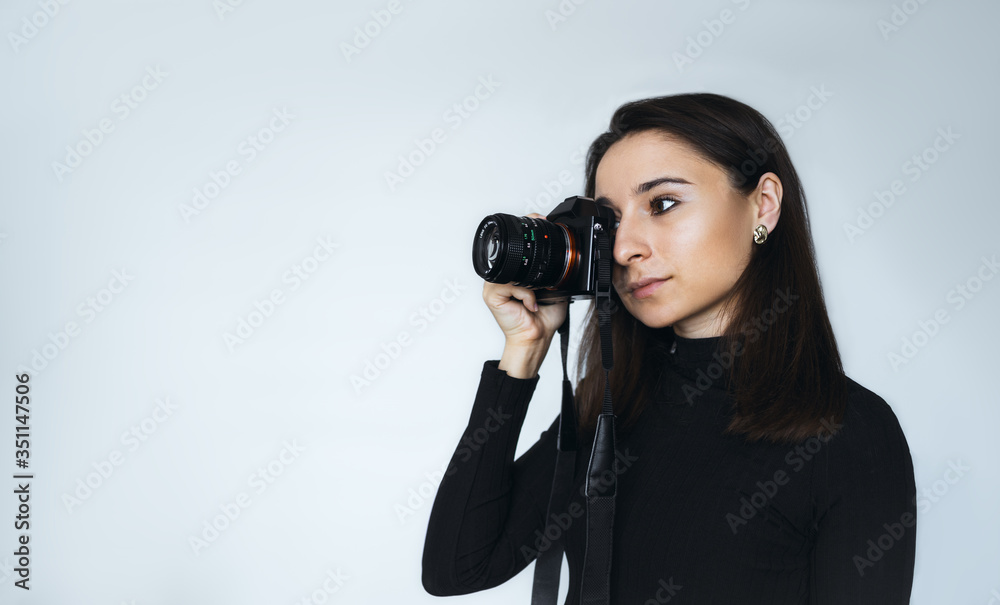Young woman photographer takes photographs with modern digital camera ...