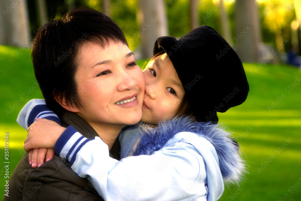 Girl giving her mother a peck on the cheek Stock Photo | Adobe Stock