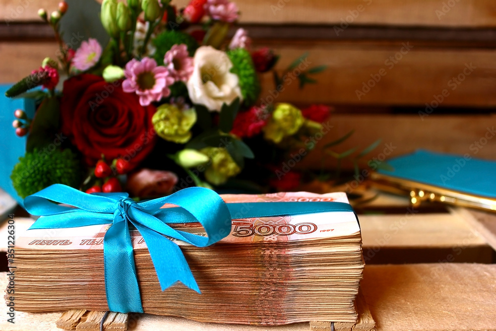 Stack of Russian banknotes and a bow with a gift ribbon. Dowry and ...