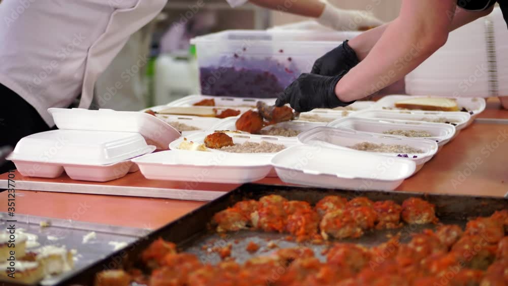 close-up, Volunteers pack free hot meals in lunchboxes, to be delivered ...