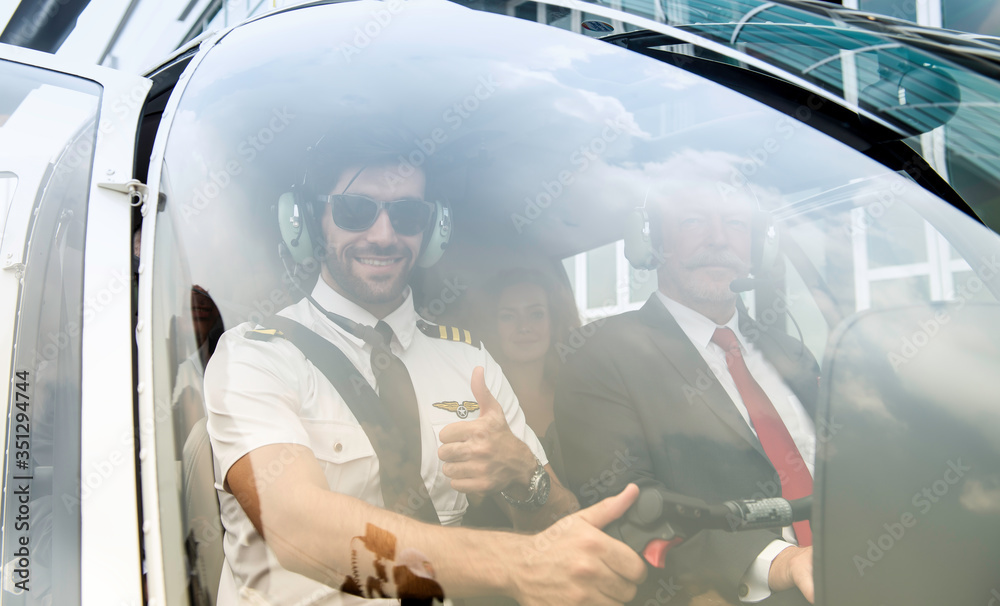 Handsome pilot in white shirt smiling while sitting in cockpit in plane ...