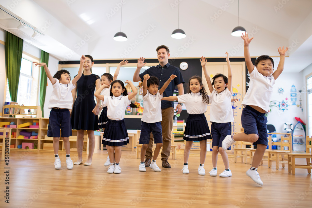 Teachers and children playing in classroom Stock Photo | Adobe Stock