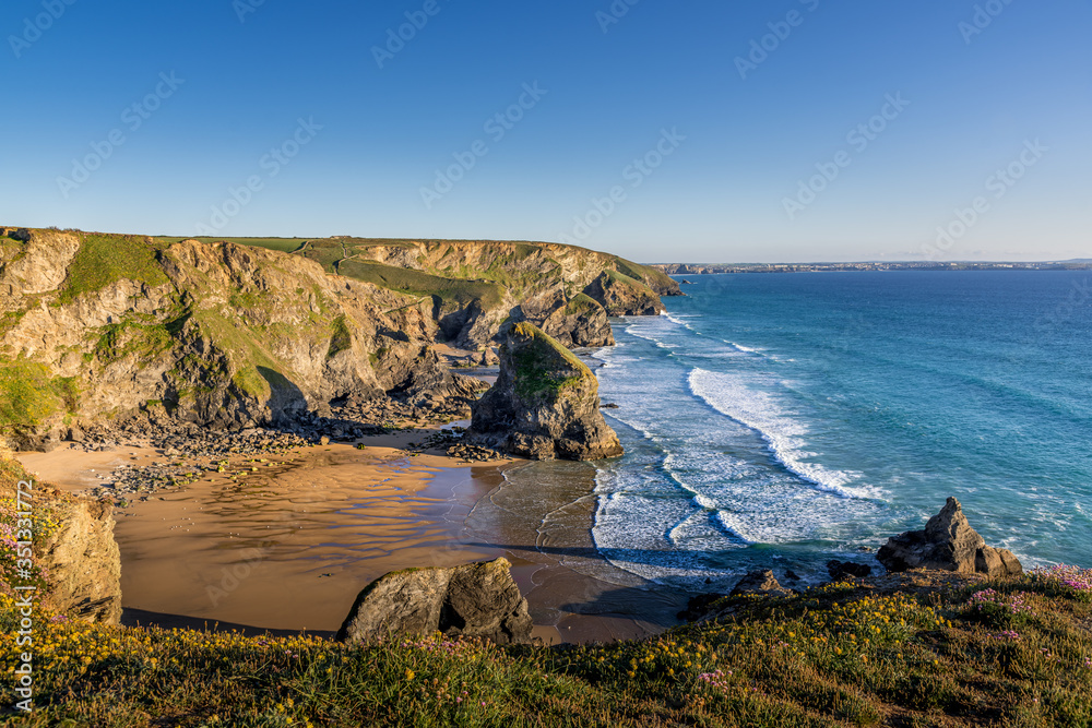 The fading sun giving a warm glow to Bedruthan Steps on the Cornish ...