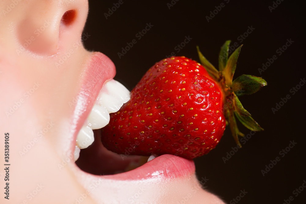 Strawberry. Red berry in female teeth. Strawberry in female mouth ...