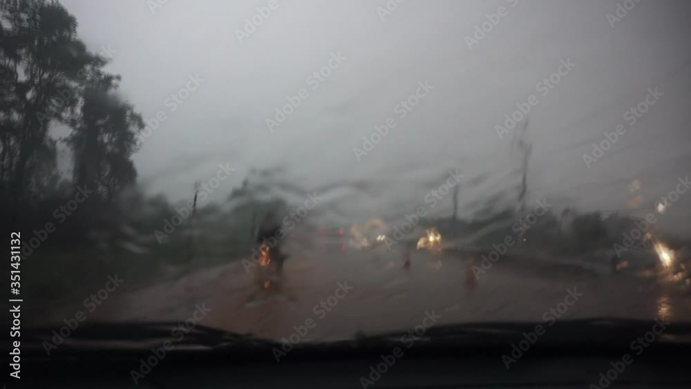 Rain falling on car windshield view. Drive car on road at heavy rain ...