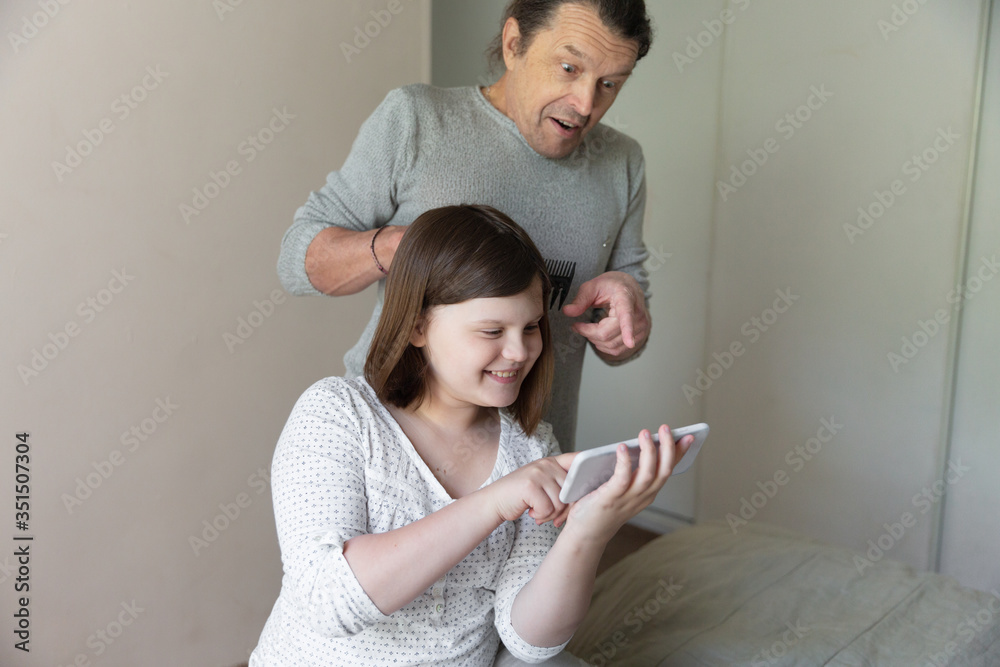 Caucasian dad learns to comb and trim daughter’s hair online. Father ...