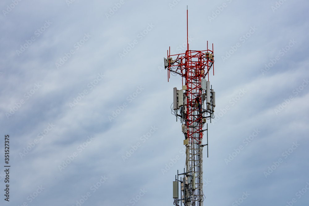 Telecommunication tower with blue sky and white clouds. Worker ...