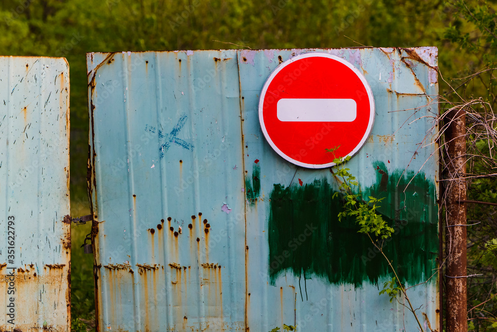 No entry road sign hanging on an old iron fence in the forest. Stock ...