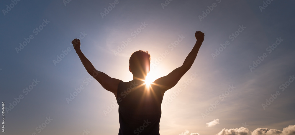 Victorious man with strong arms up in the sunset sky. People power and ...