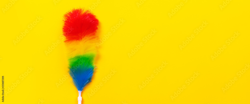 Colorful feather duster on yellow background. Cleaning concept. Stock ...