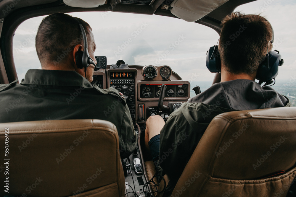 Pilot in cockpit. Aircraft Pilot at work. Rear view of pilots. Rear ...
