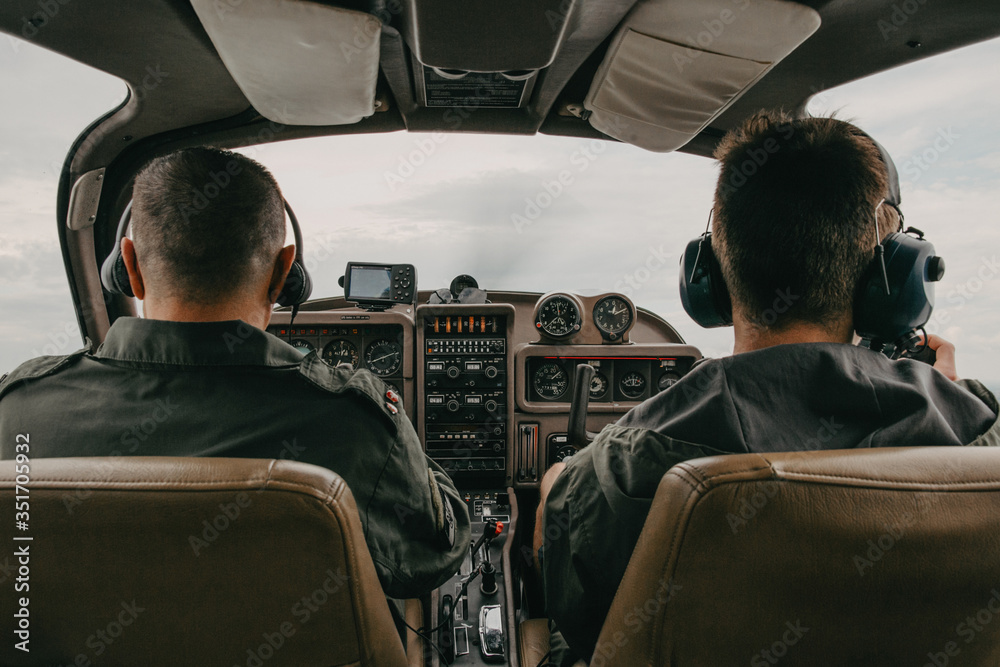 the cockpit of the pilot. Pilots are cooperating during a flight on a ...
