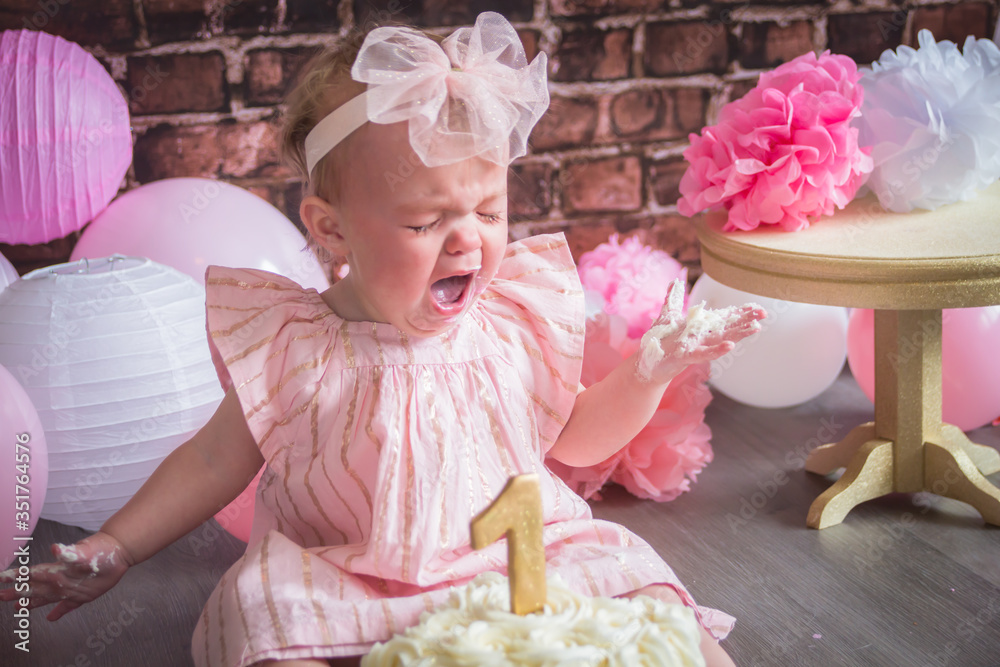 crying girl at her birthday party cake smash Stock Photo | Adobe Stock