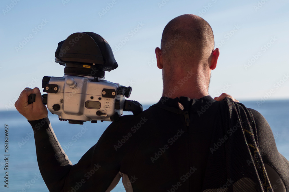 underwater photographer with a scuba cam wearing a neopren swimming ...