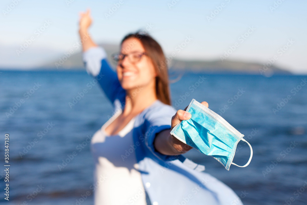 Happy woman take off medical mask at sea beach. Corona free countries ...