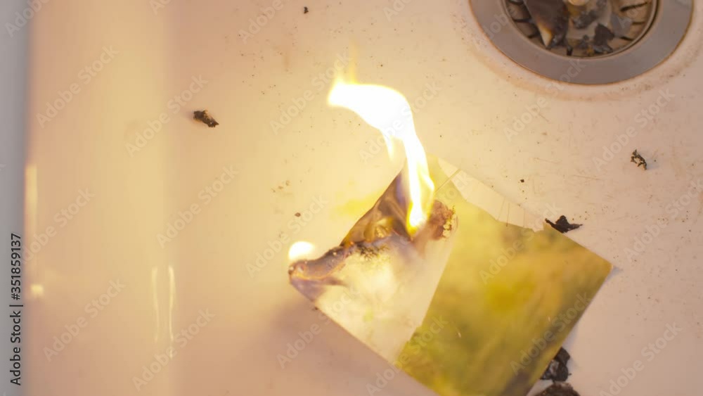 Close up wedding photo burning in the kitchen sink. Then water starts ...