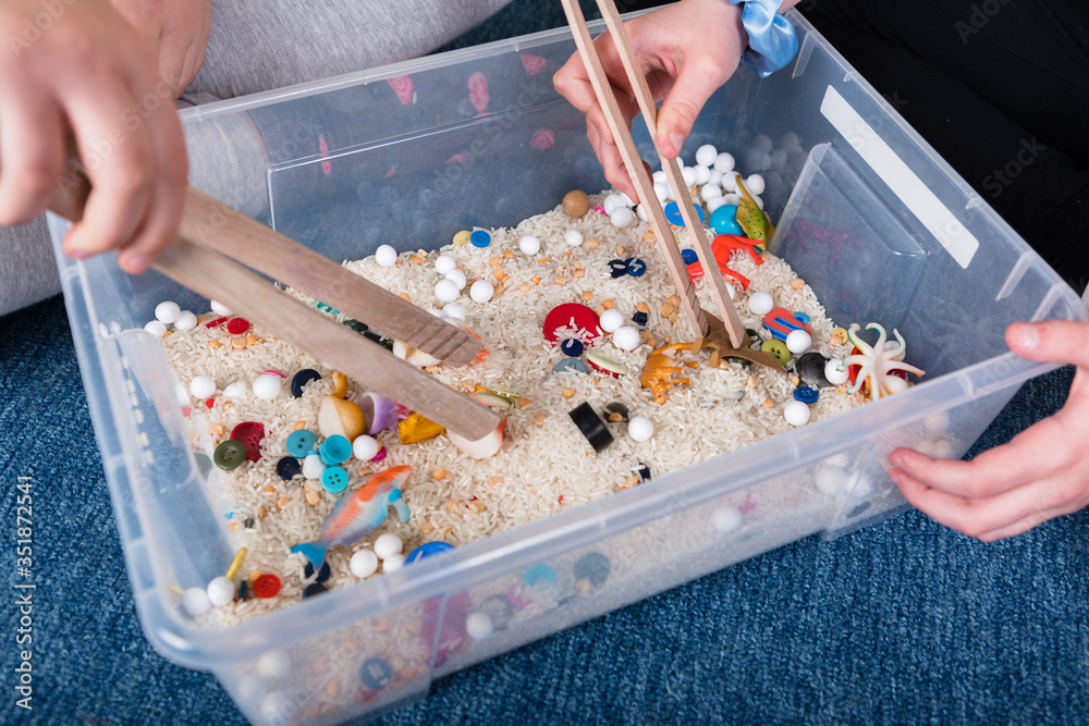 Sensory integration therapy - picking up small objects with tongs from ...