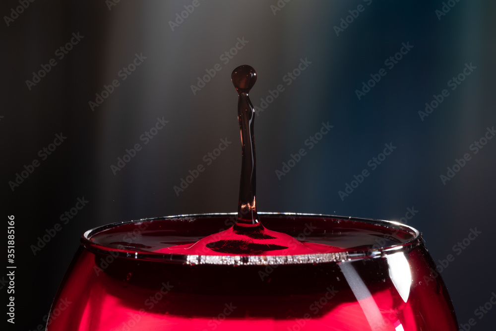 Red wine splash. Reaction of a falling drop on a red wine surface in a ...