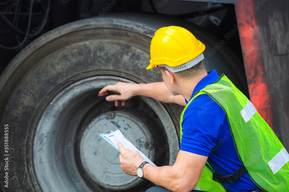 Mechanics checking wheel in cargo container. Professional technician ...