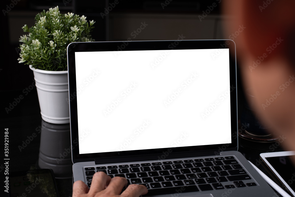 Mockup of man working and looking at blank screen laptop computer at ...