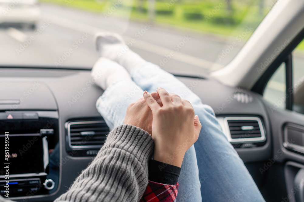 Woman feet in socks on car dashboard. Man driver holds the hand of a ...