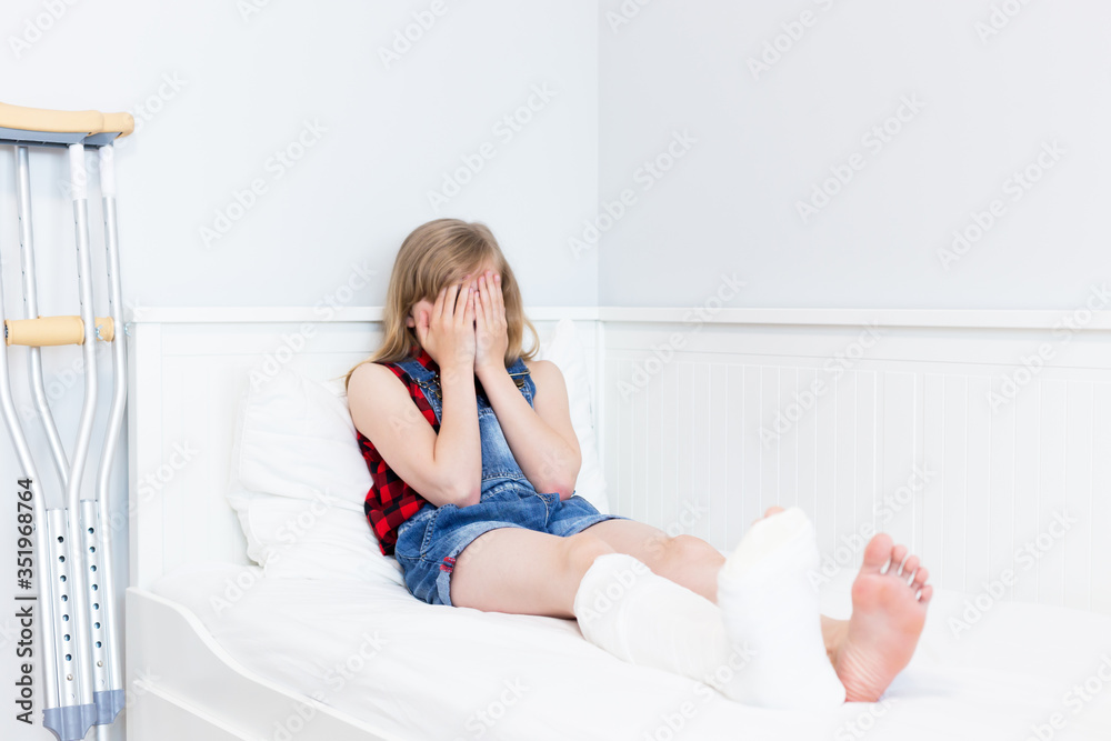 Girl schoolgirl crying at home. In full growth. A broken leg in a cast ...