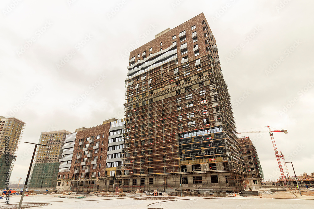 Tall building under construction with scaffolds. Construction site ...