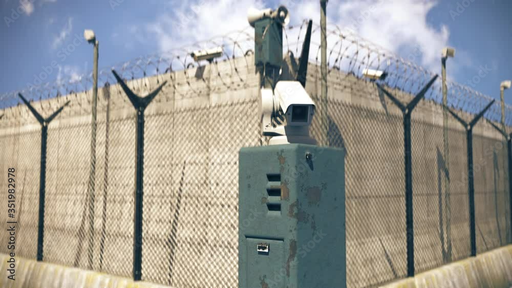 CCTV camera monitoring heavily guarded building, penitentiary, military ...