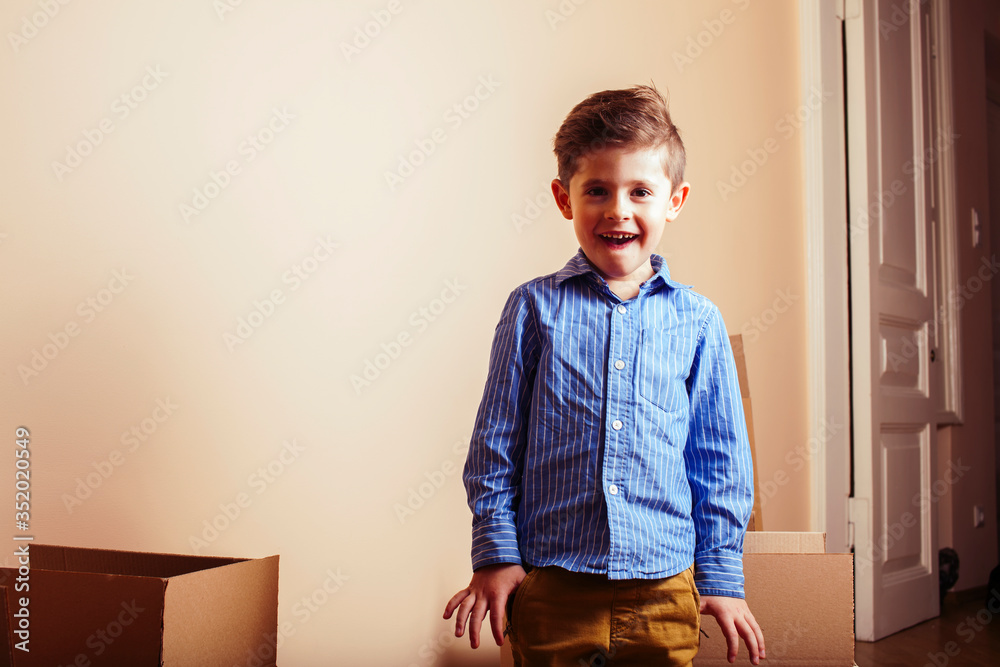 little cute boy in empty room, move to new house. home alone among ...