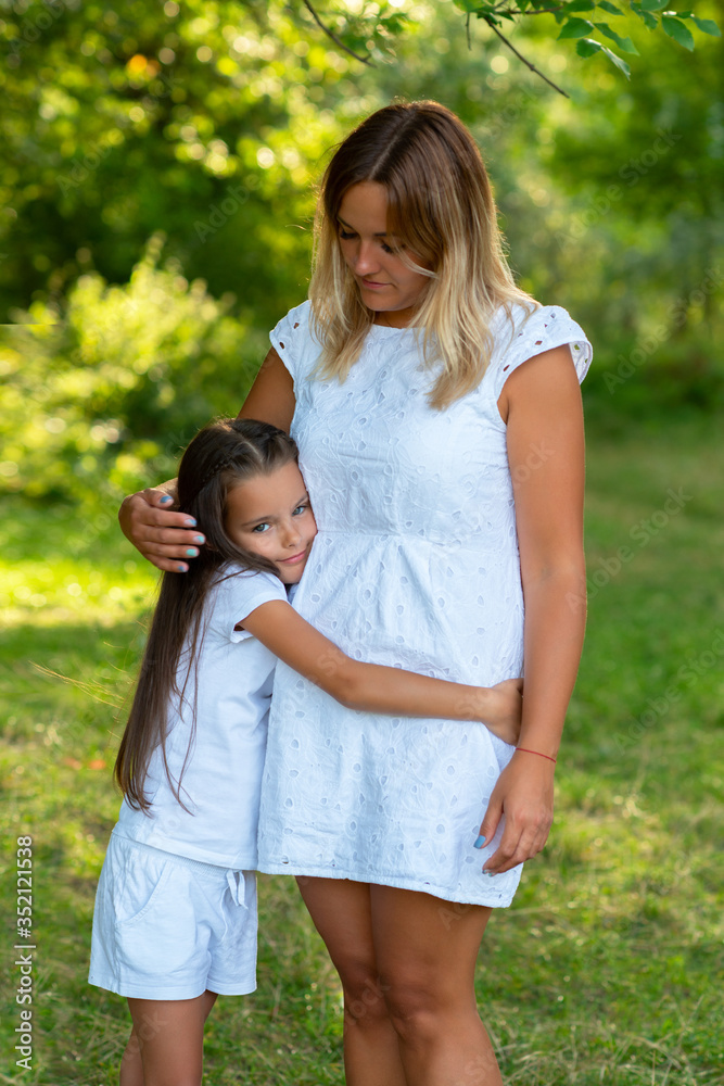 Little girl hugs mother, summer nature outdoor. Mom and daughter ...
