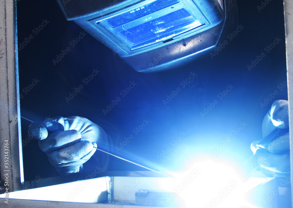 A vibrant action shot of a skilled working metal welder in action ...