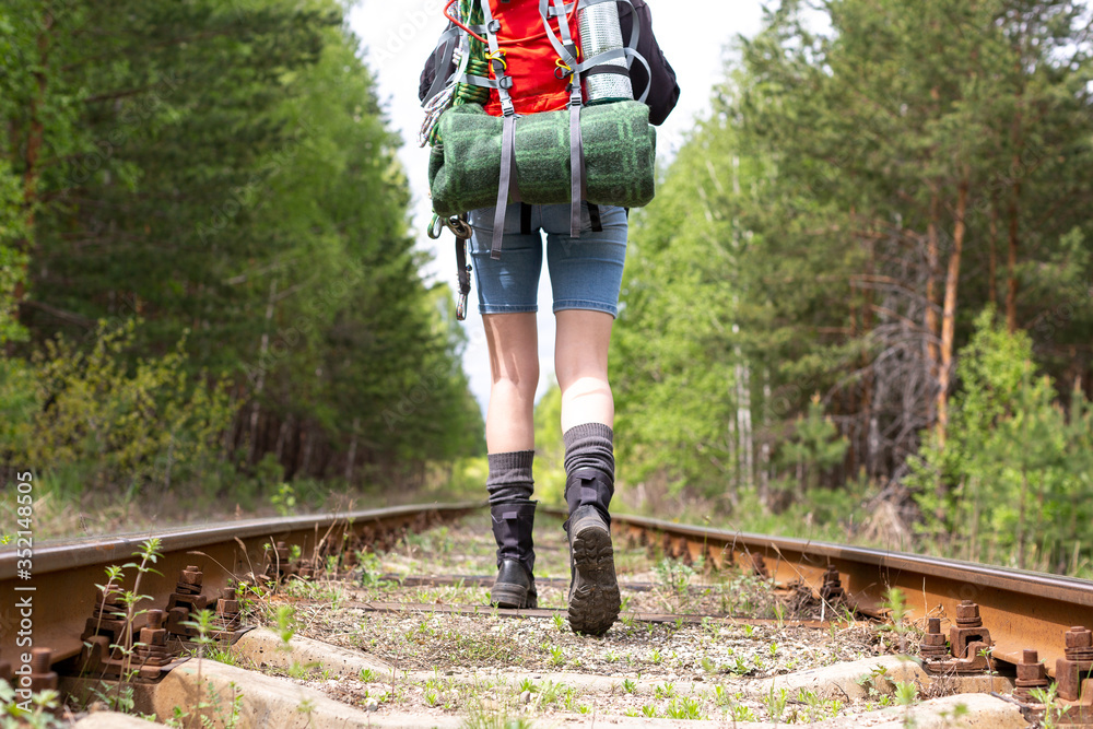 Legs of hiker with big backpack, back view, wide angle. Caucasian woman ...