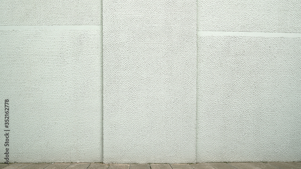 stylish building with light grey wall near empty sidewalk with grey ...