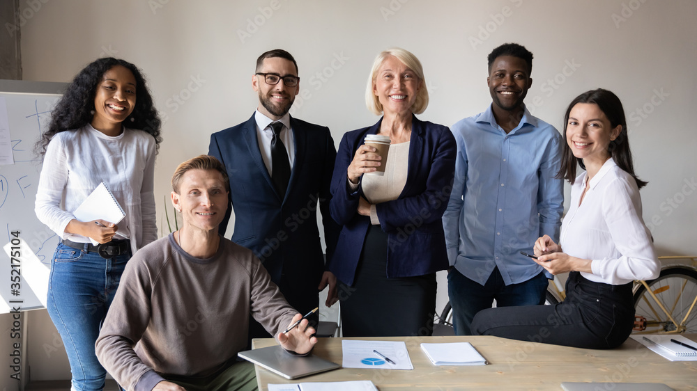 Successful diverse employees with team leader looking at camera, posing ...
