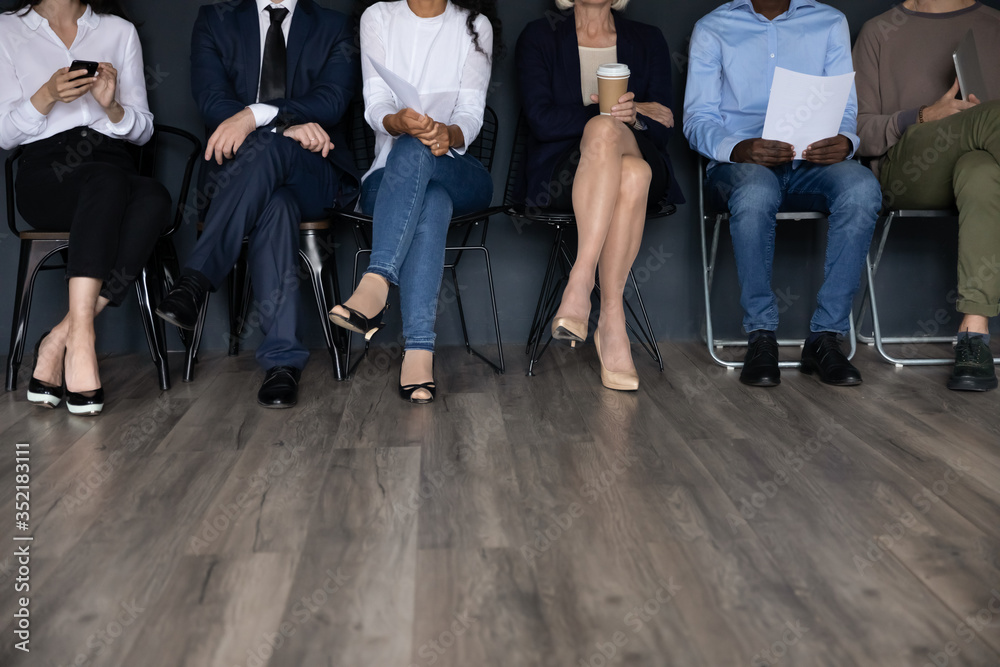 Diverse people sitting on chairs in row, six female and male applicants ...