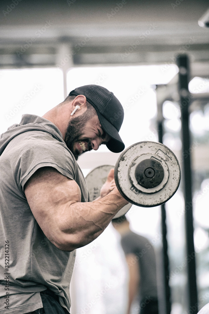 sport motivation concept of strong young athlete man with beard lifting ...