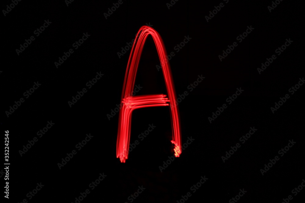 Long exposure photograph of the letter a in neon red colour fairy ...